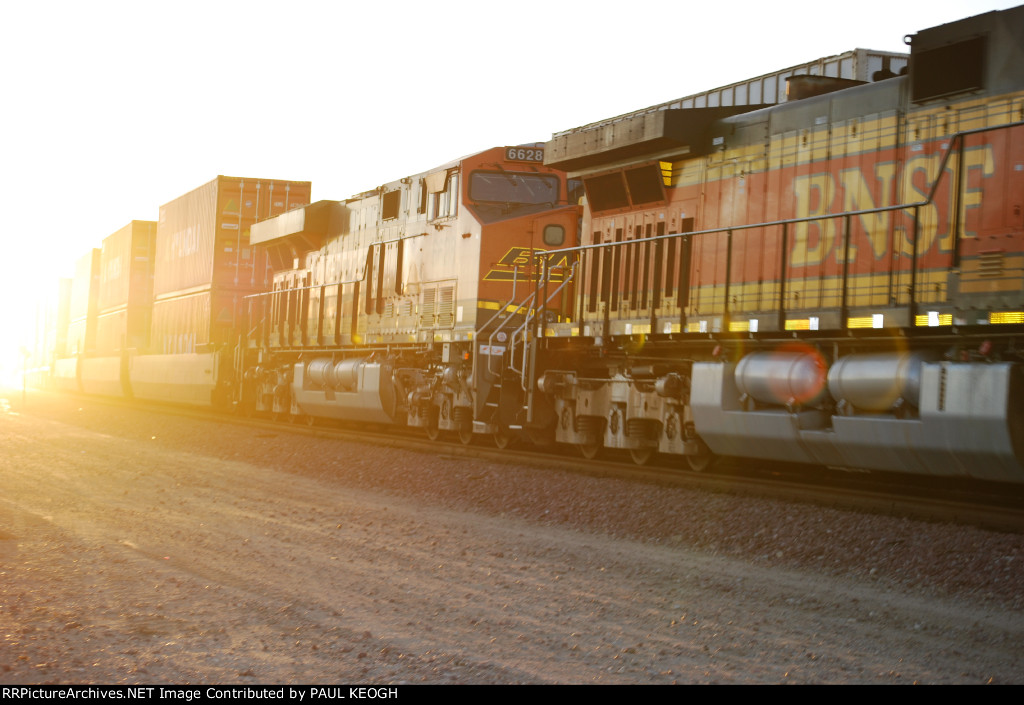 BNSF 6628 pushes a westbound Z-Train into a Blinding Sun as a rear DPU.